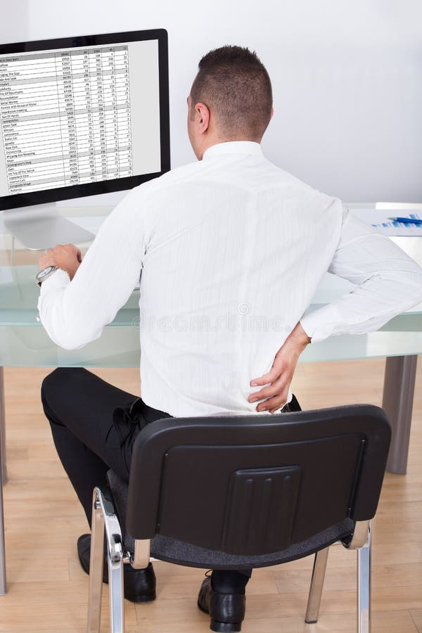Businessman with Backache Using Computer at Desk Stock Photo - Image of ...