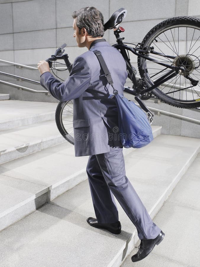 Businessman Carrying Bicycle Up Steps Stock Photo - Image of suit ...