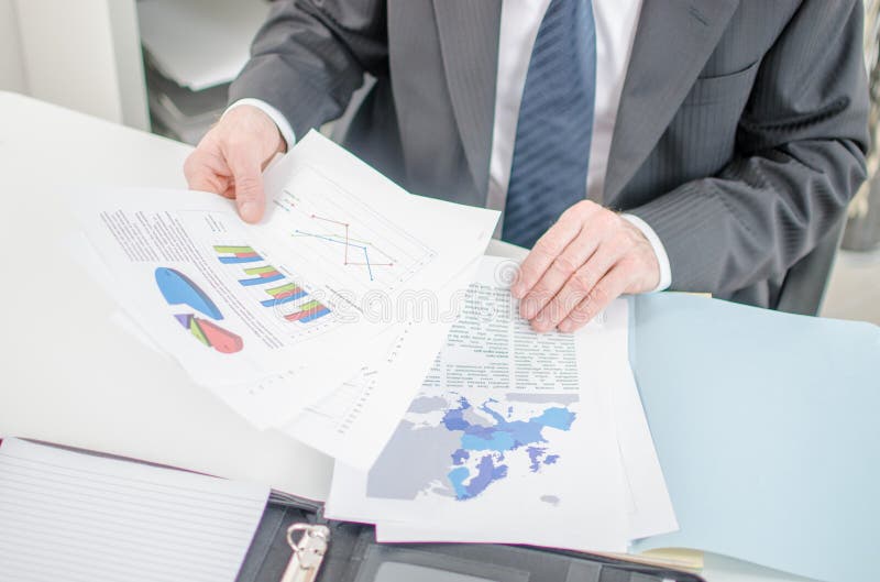 Businessman Checking a File with Financial Graphs Stock Image - Image ...