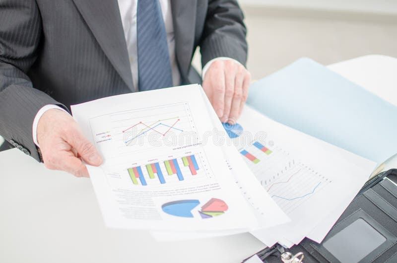 Businessman Checking a File with Financial Graphs Stock Image - Image ...