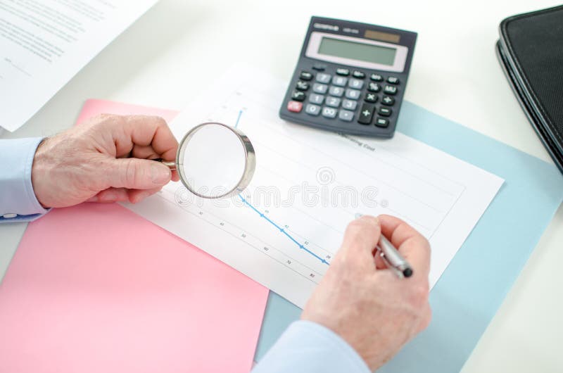 Businessman Checking a Graph with a Magnifying Glass Stock Photo ...