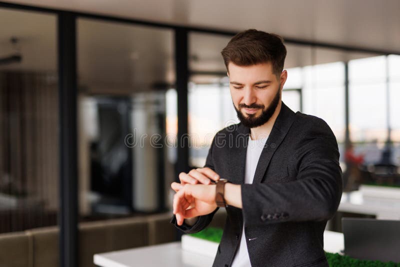 Young Businessman Checking the Time in Office Stock Image - Image of ...