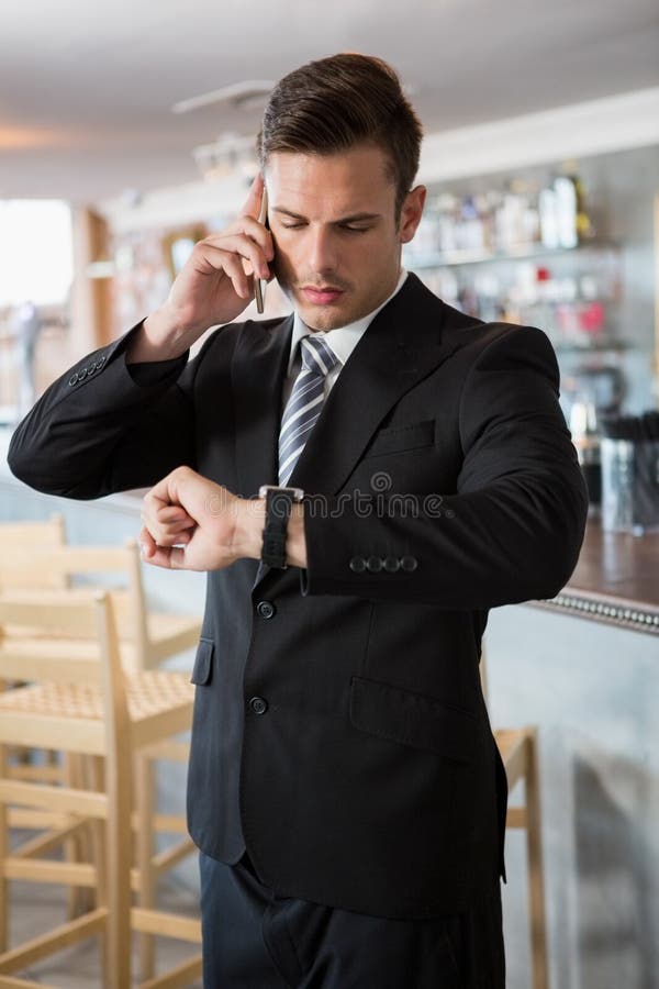 Businessman Checking Time while Talking on the Mobile Phone Stock Photo ...