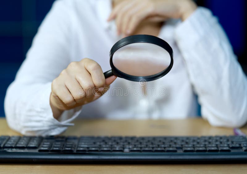 A Businessman Checks Computer Equipment with a Magnifying Glass ...