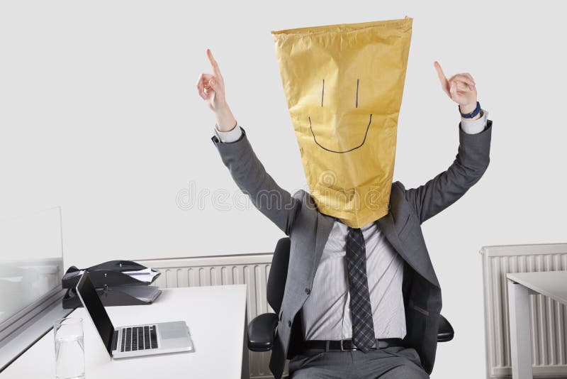 Businessman Cheering with Smiley Drawn on Paper Bag Over Face in Office ...