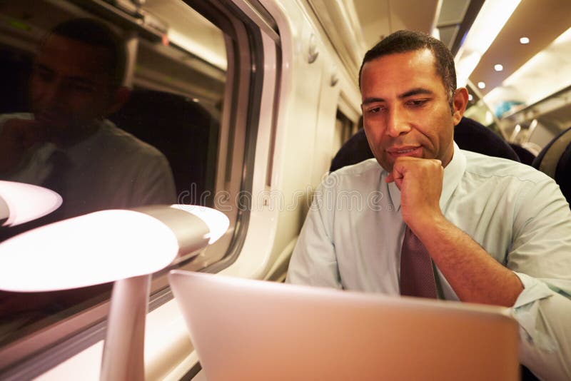 Businessman Commuting To Work on Train and Using Laptop Stock Photo ...