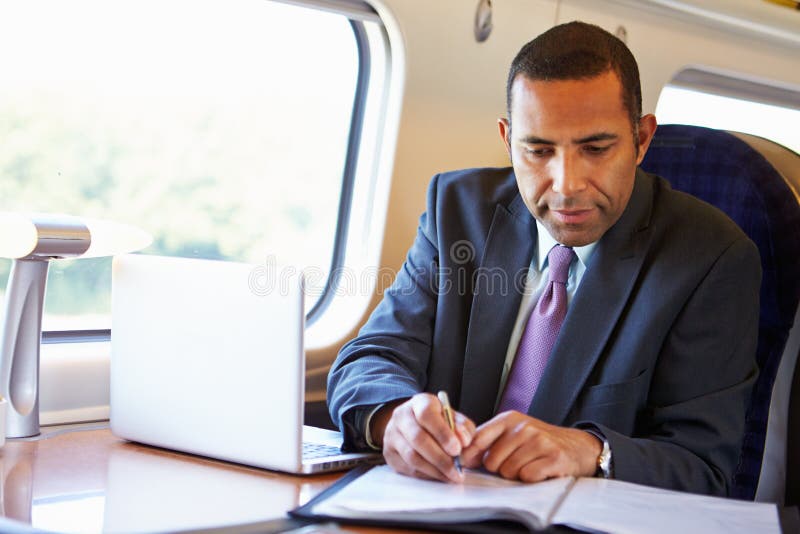 Businessman Commuting To Work on Train and Using Laptop Stock Photo ...