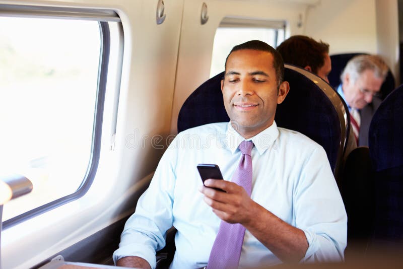Businessman Commuting To Work on Train Using Mobile Phone Stock Photo ...