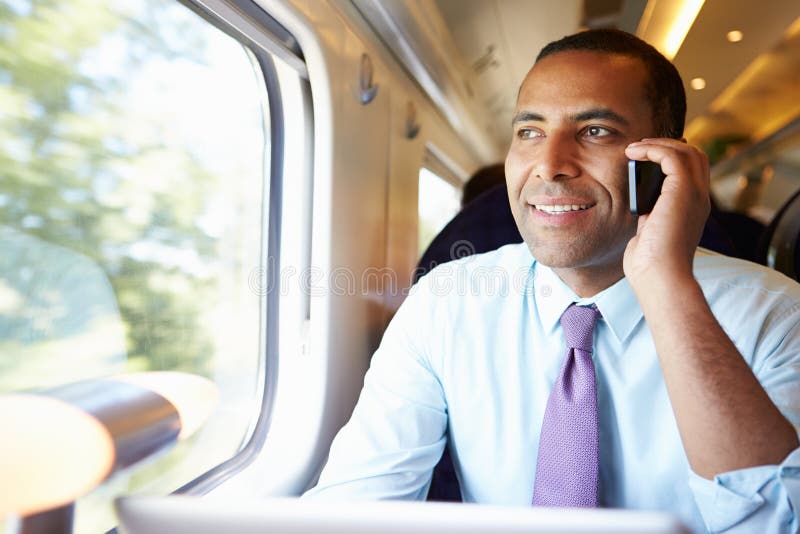 Businessman Commuting To Work on Train Using Mobile Phone Stock Photo ...