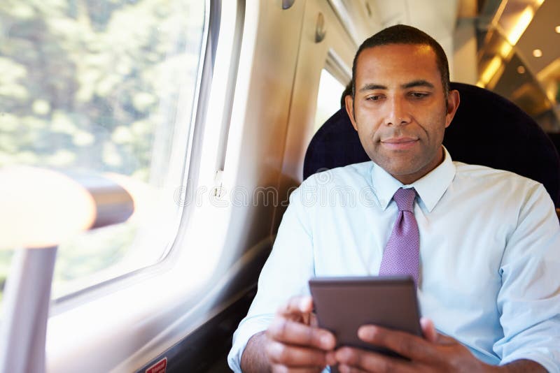 Businessman Commuting on Train Reading a Book Stock Image - Image of ...