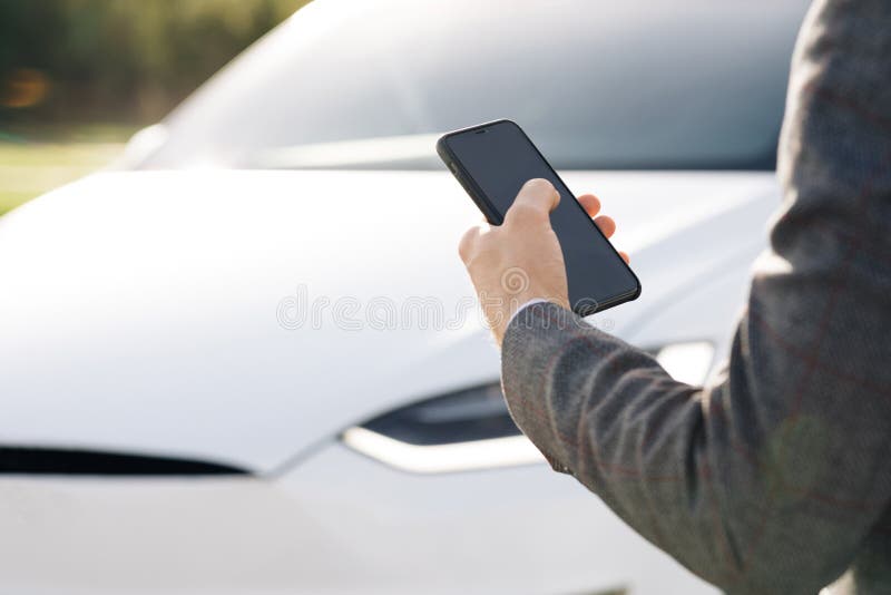 Businessman Controls a Self-driving Electric Car Using Mobile ...