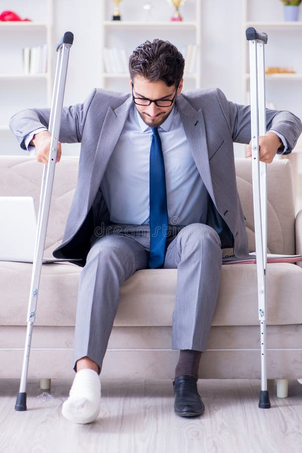 The Businessman with Crutches and Broken Leg at Home Working Stock ...