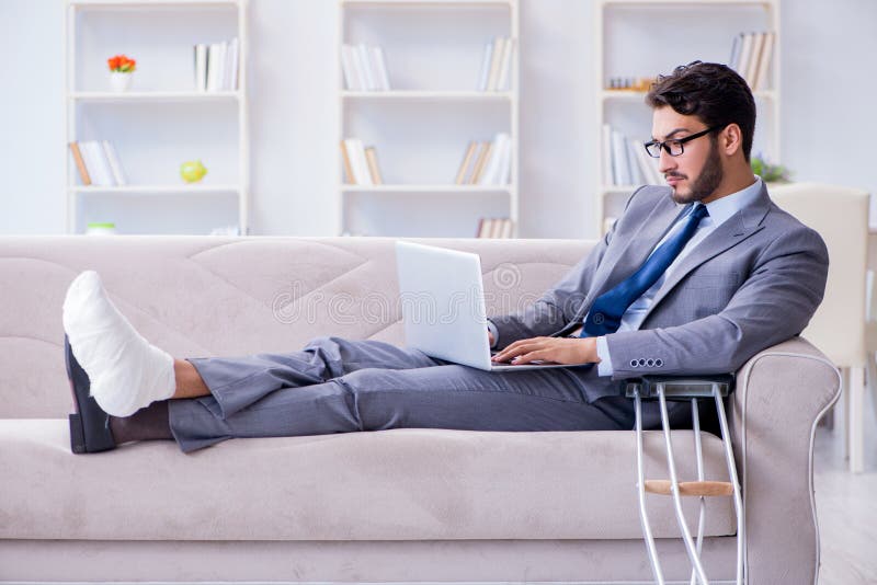 The Businessman with Crutches and Broken Leg at Home Working Stock ...