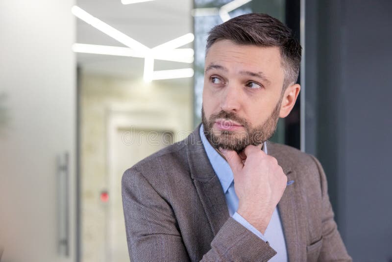 Businessman Deep in Thought Against Modern Office Backdrop Stock Photo ...