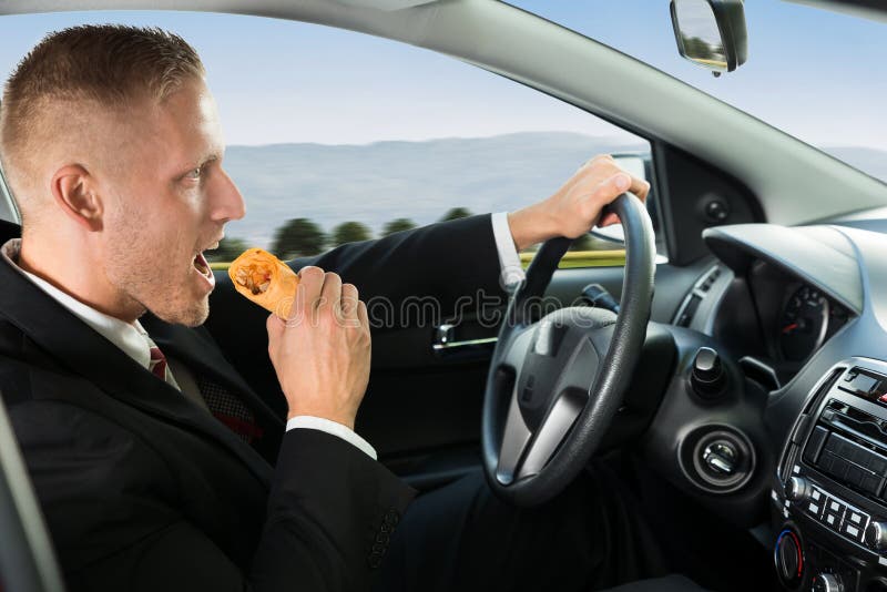 Businessman Eating Snack while Driving Stock Photo - Image of hungry ...