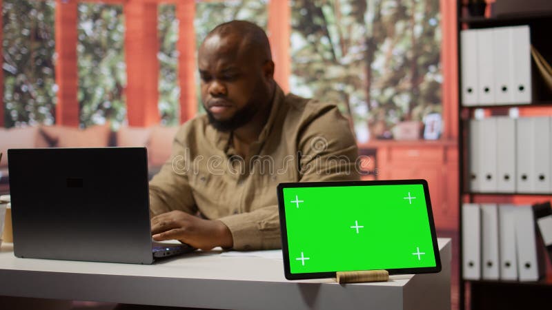 Businessman Examines Annual Sales Reports on Documents Next To a Green ...