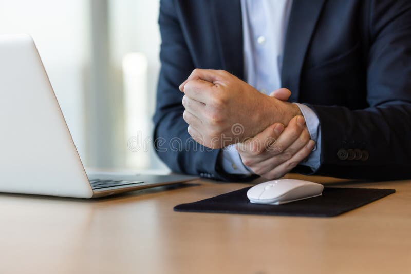 Businessman Experiencing Wrist Pain while Working on Laptop at Desk ... Businessman Experiencing Wrist Pain while Working on Laptop at Desk ...