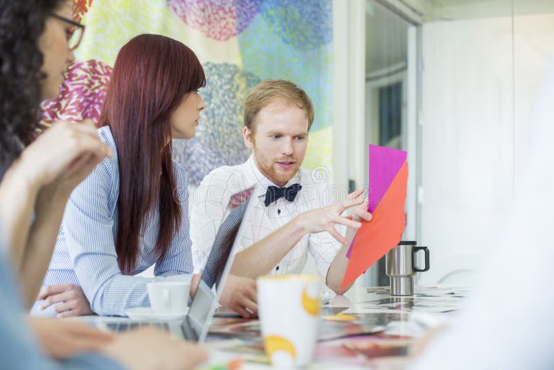 Businessman Explaining Documents To Female Colleagues in Creative ...