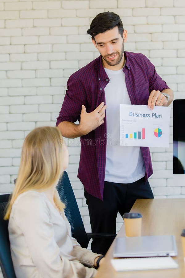 A Businessman Explaining the Information on a Chart for His Colleagues ...