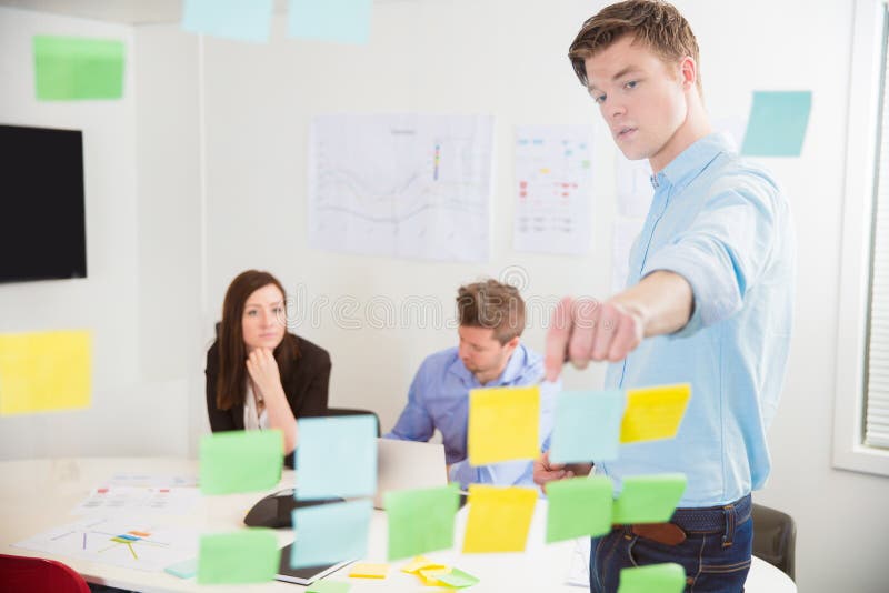 Businessman Explaining Notes To Colleagues in Office Stock Photo ...