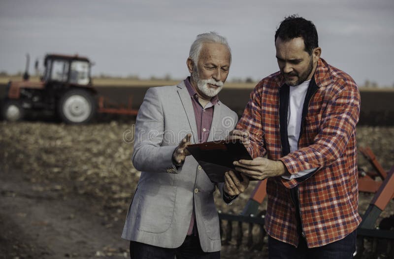 Businessman and Farmer Signing Documents in Field Stock Photo - Image ...