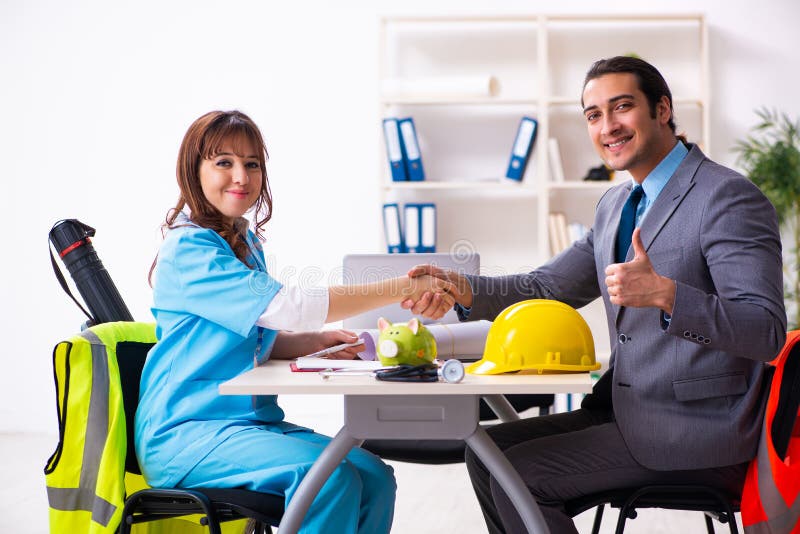 Young Businessman and Female Doctor Discussing Construction Proj Stock ...