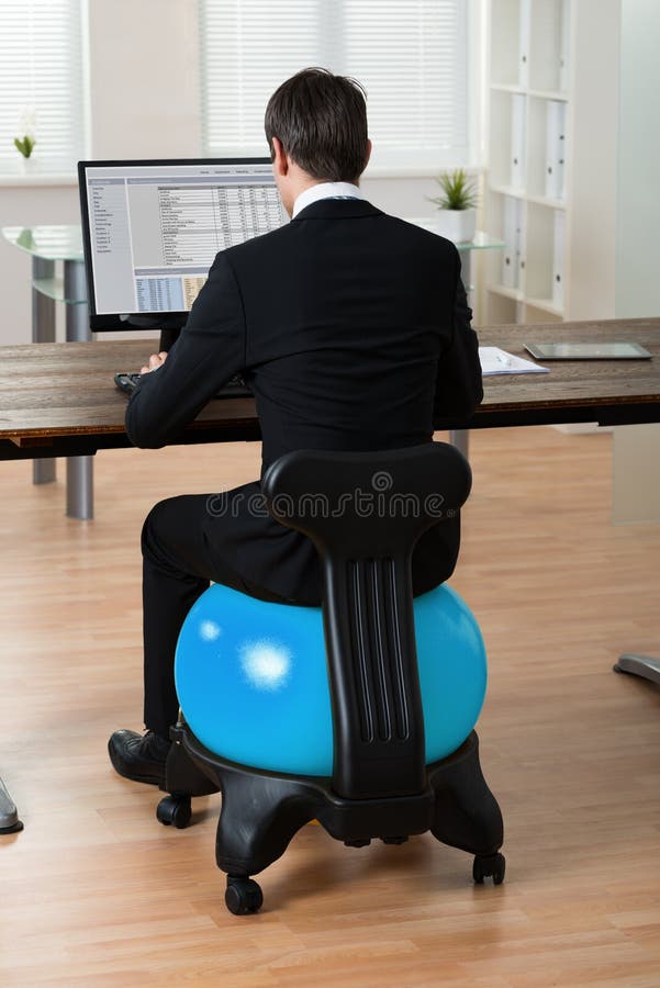 Businessman in Front of Computer Sitting on Pilates Ball Stock Image ...