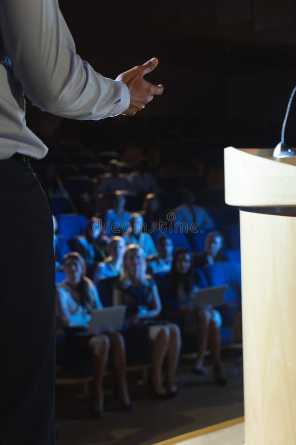 Businessman Giving Presentation in Front of Audience in Auditorium ...