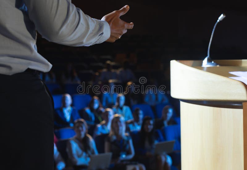 Businessman Giving Presentation in Front of Audience in Auditorium ...