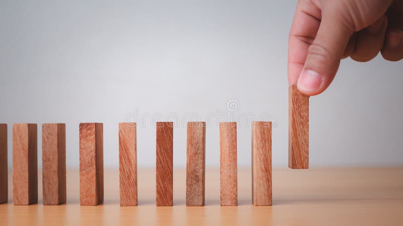Businessman Hand Stopping Falling Blocks on Table, Stopping the Domino ...