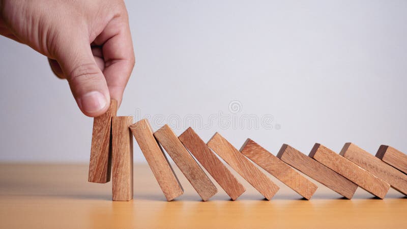 Businessman Hand Stopping Falling Blocks on Table, Stopping the Domino ...