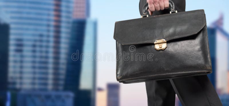 Businessman Holding a Briefcase with Office Buildings in Background ...