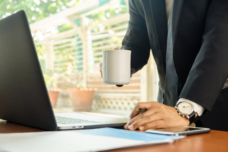 Businessman Holding Coffee Mug with Laptop on Table. Stock Image ...