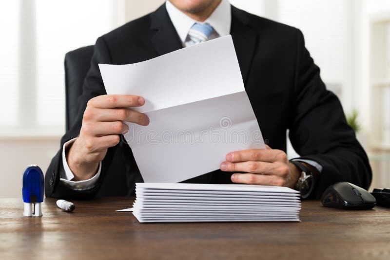 Businessman Holding Document at Desk Stock Image - Image of indoors ...