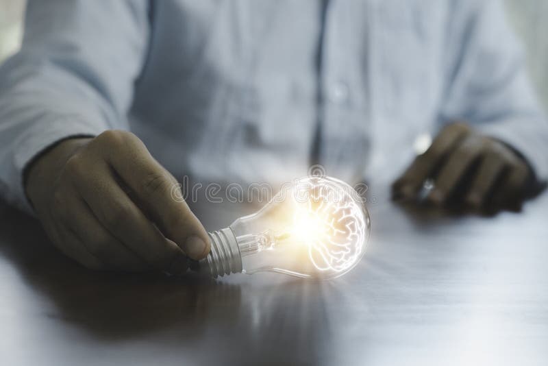 Businessman Holding Glowing Lightbulb and Using Computer Laptop To ...