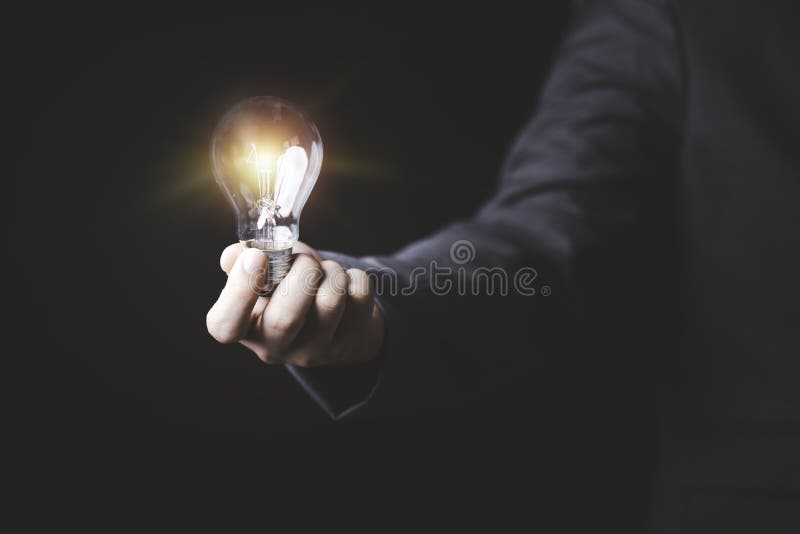 Businessman Holding Glowing Lightbulb and Using Computer Laptop To ...