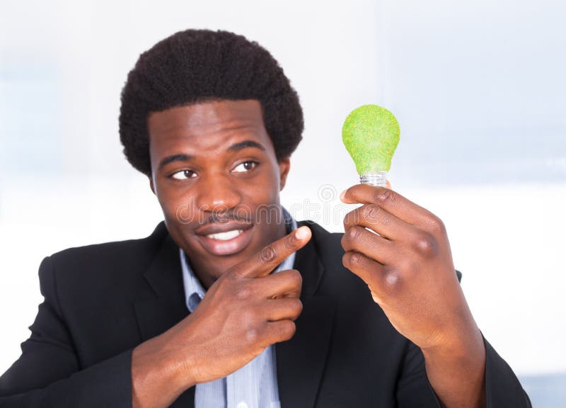Businessman Holding Light Bulb with Green Grass Stock Image - Image of ...