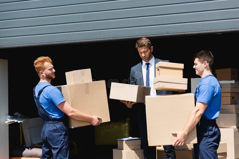 Businessman Holding Packages Near Movers and Stock Photo - Image of ...