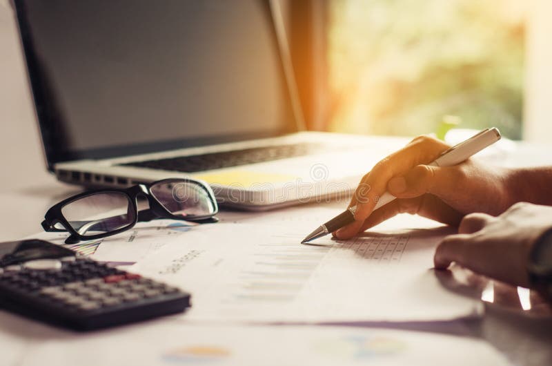 Businessman Holding Paperwork On The Table And Analyzing Stock Photo ...