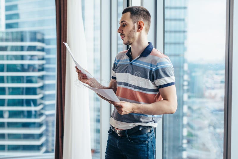 Businessman Holding Reading Documents Standing by the Window in Office ...