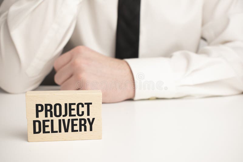 Businessman Holding Sheet of Paper with a Message PROJECT DELIVERY ...