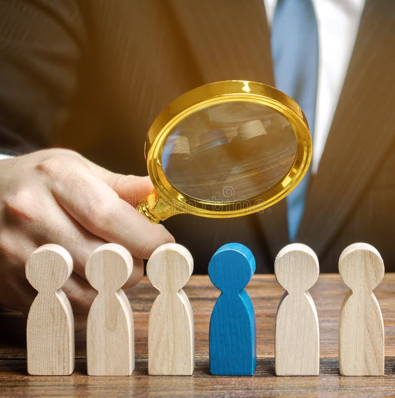 Businessman Holds A Magnifying Glass Over A Worker Recruitment Concept