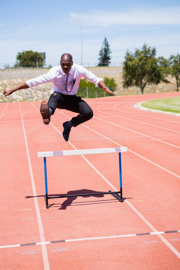Businessman Jumping a Hurdle while Running Stock Image - Image of ...
