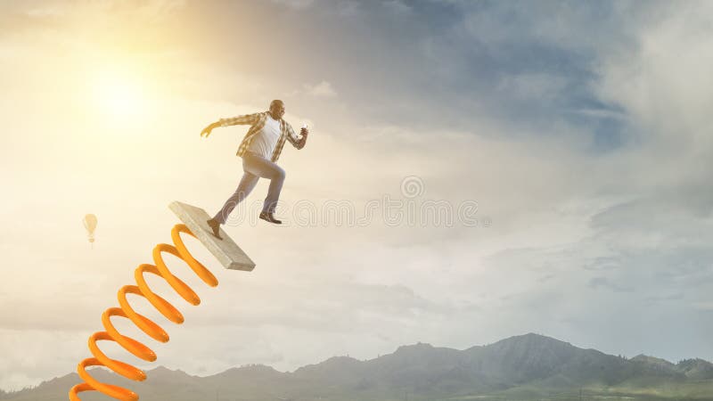 Businessman Jumping on Springboard . Mixed Media Stock Photo - Image of ...