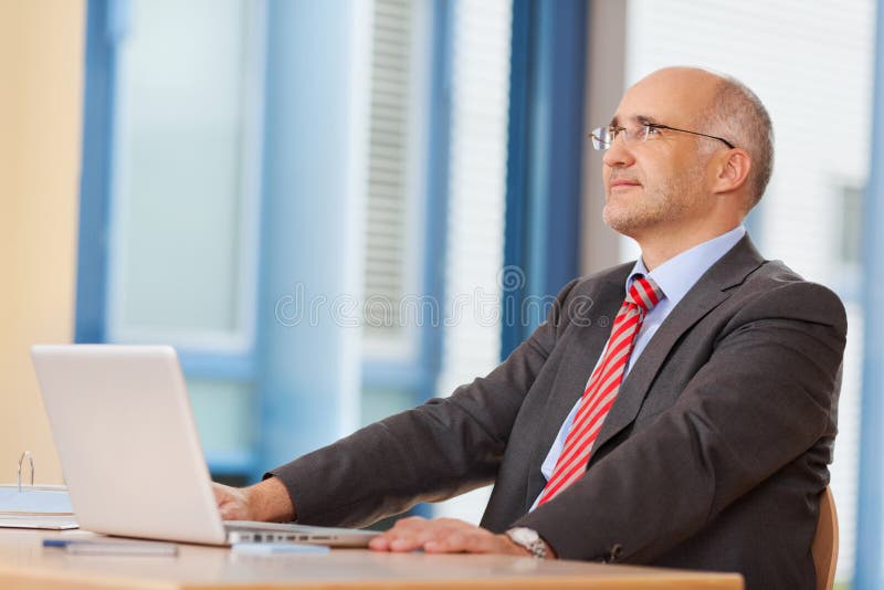 Businessman with Laptop Looking Up at Office Desk Stock Image - Image ...