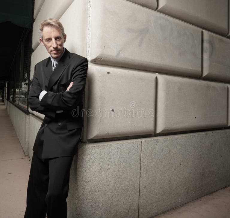 Businessman Leaning on a Building Stock Photo - Image of staring ...