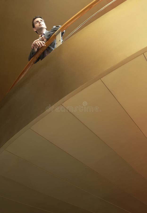 Businessman Leaning on Railing in Office Stock Photo - Image of adult ...