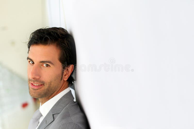 Businessman Leaning on White Wall Isolated Stock Photo - Image of ...