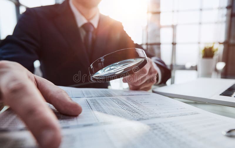 Businessman Looking through a Magnifying Glass To Documents Note in the ...