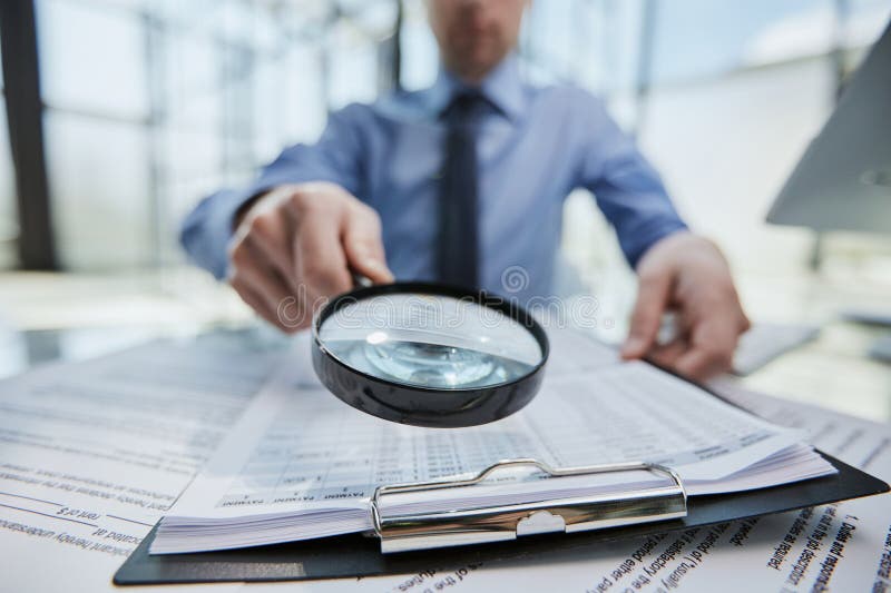 Man Looking through a Magnifying Glass To Documents Notebook. Stock ...